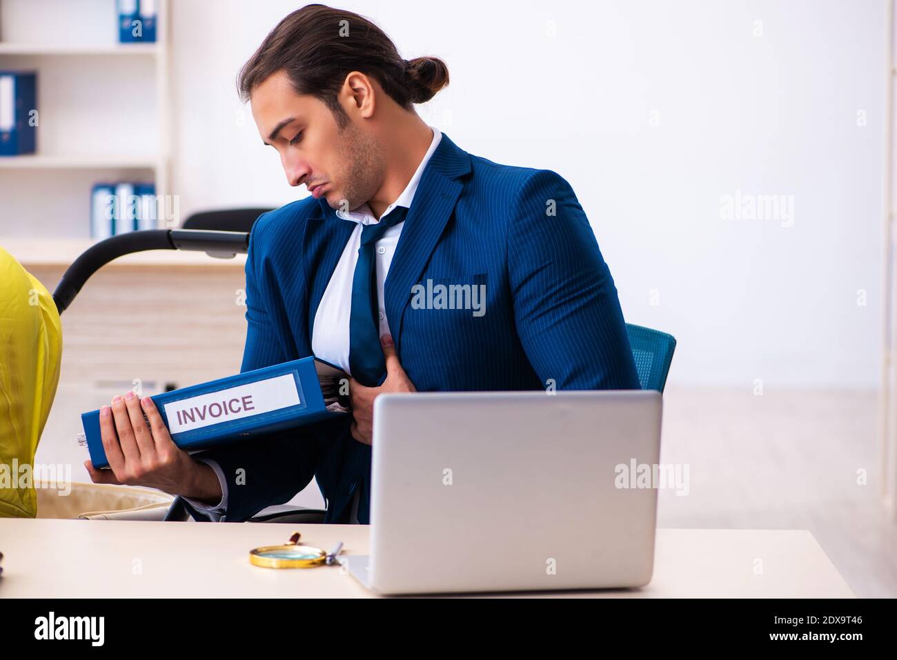 Young employee looking after kid at workplace Stock Photo - Alamy