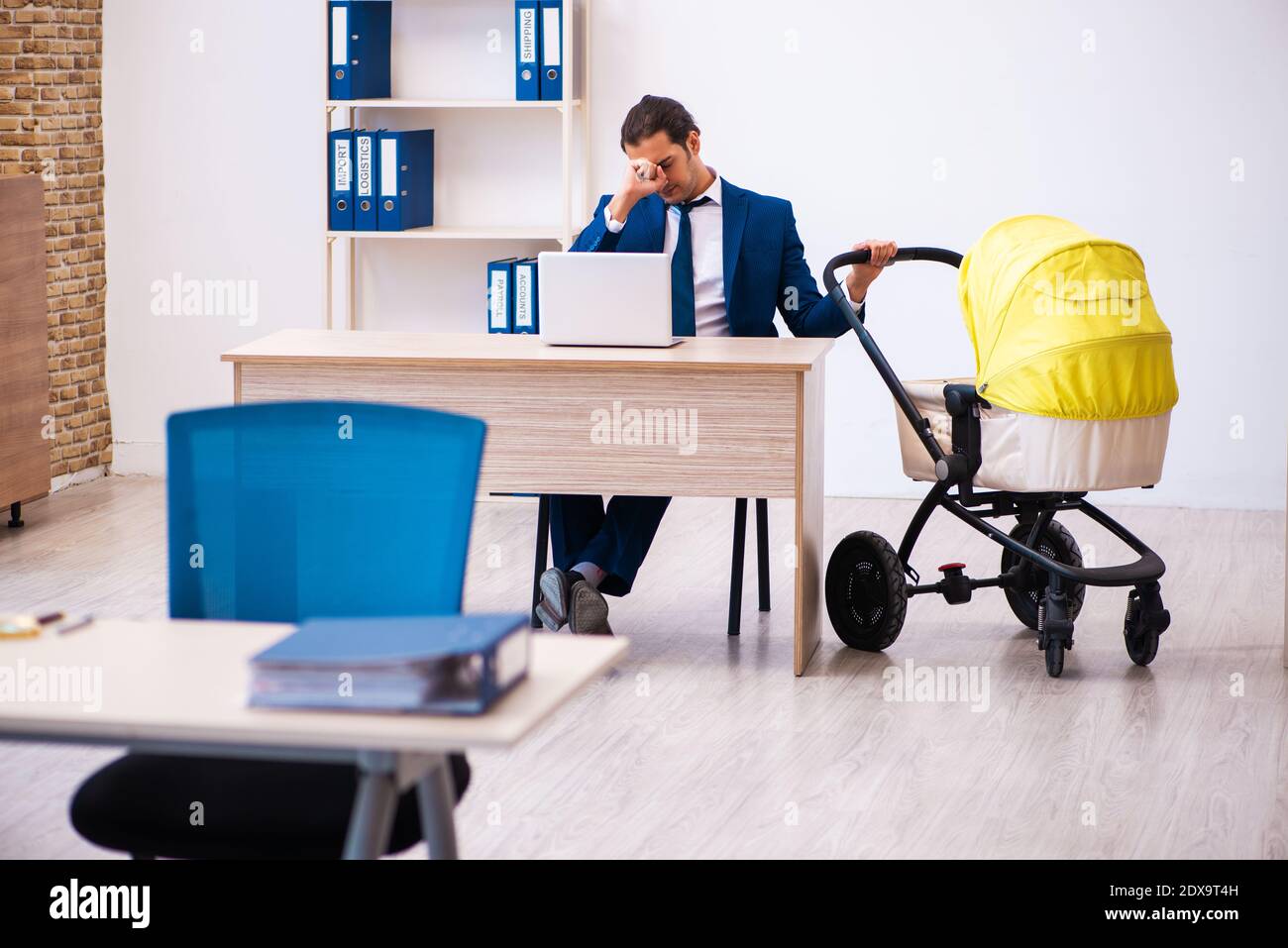 Young employee looking after kid at workplace Stock Photo - Alamy