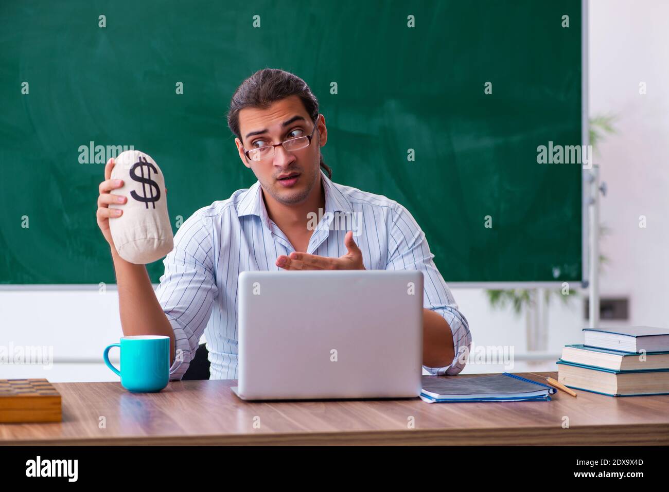 Young teacher in remuneration concept Stock Photo - Alamy