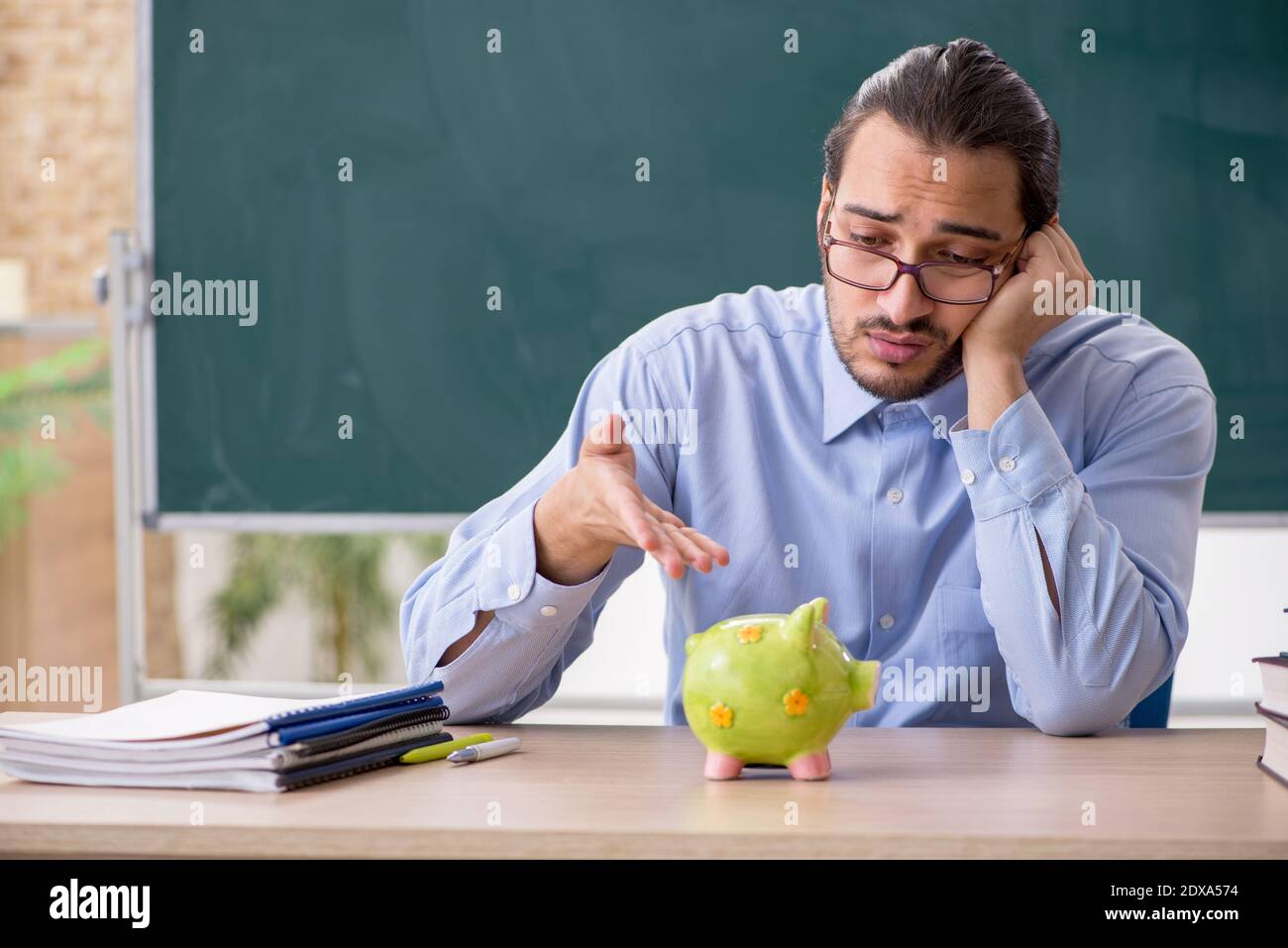 Young underpaid teacher in the classroom Stock Photo - Alamy