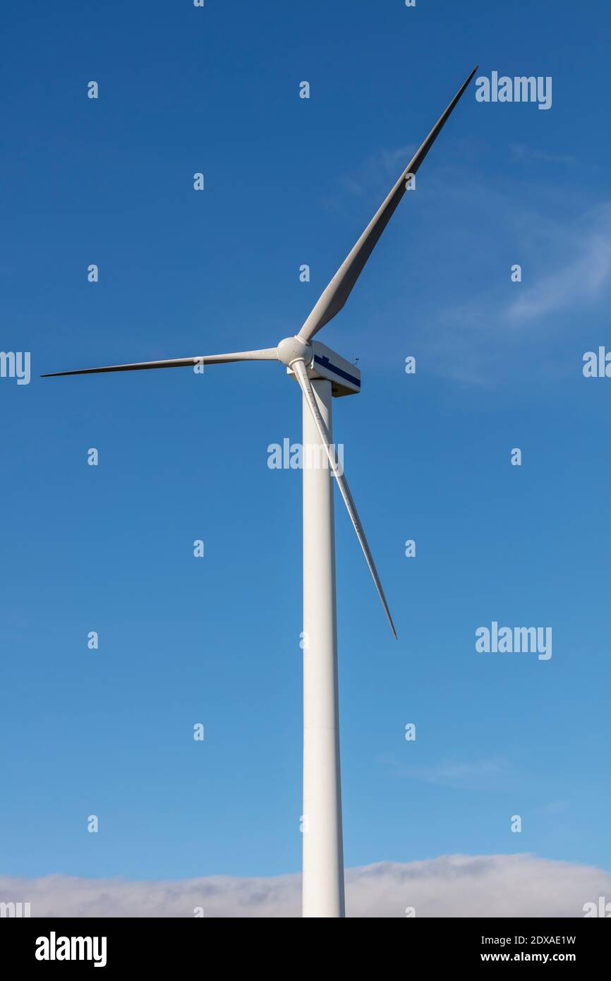 A large three blade industrial wind turbine generating electricity in a ...