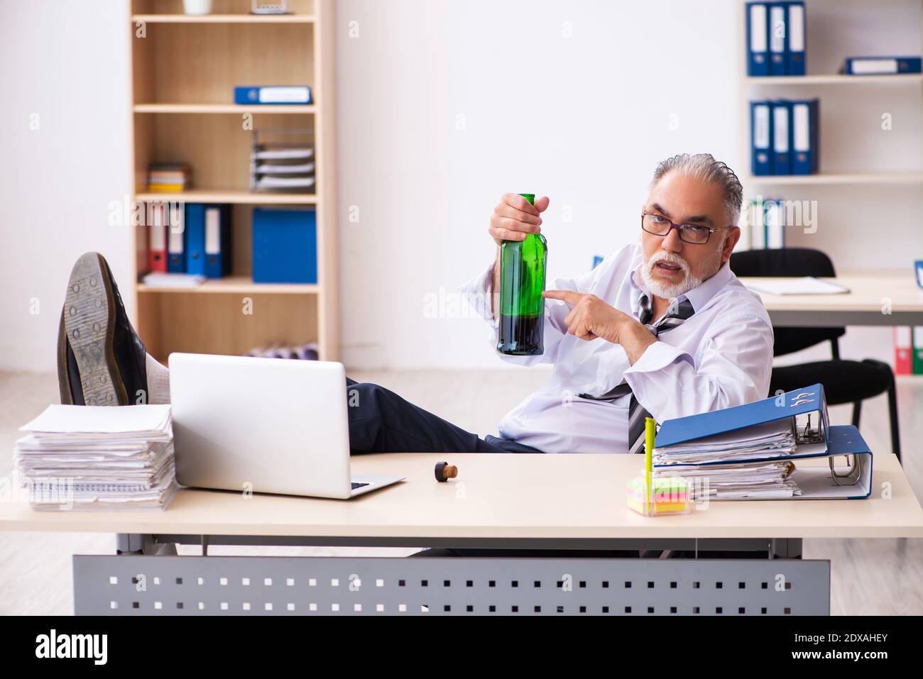 Old businessman drinking alcohol in the office Stock Photo - Alamy