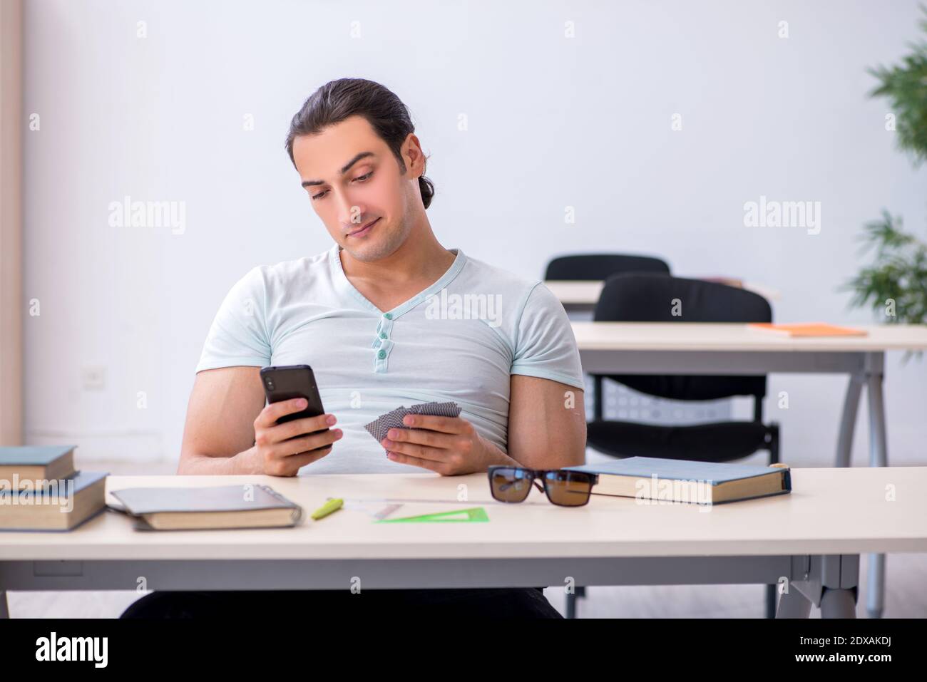 Male student playing cards during exam preparation in the classroom ...