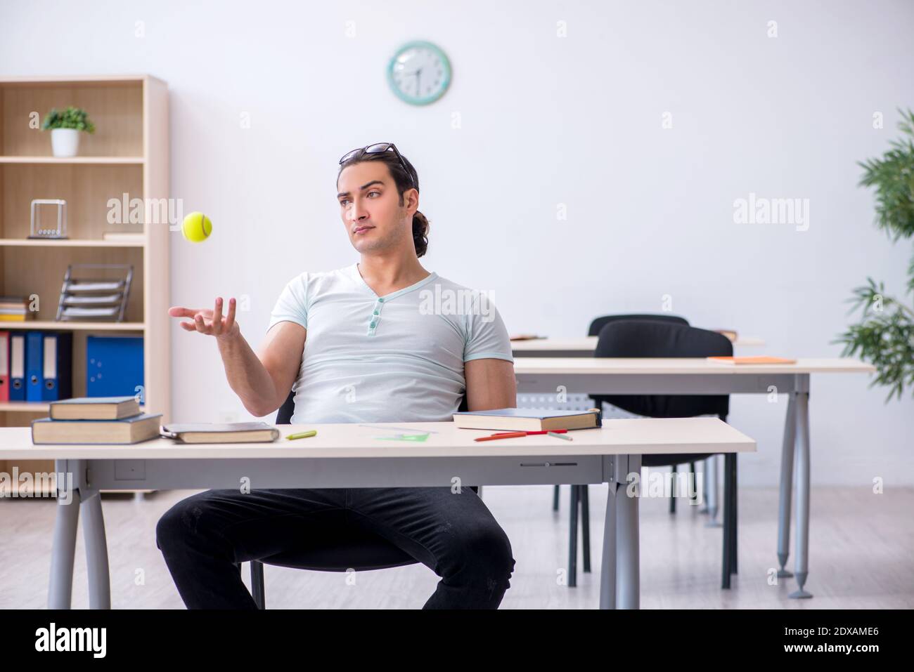 Male student throwing tennis ball during exam preparation in the ...
