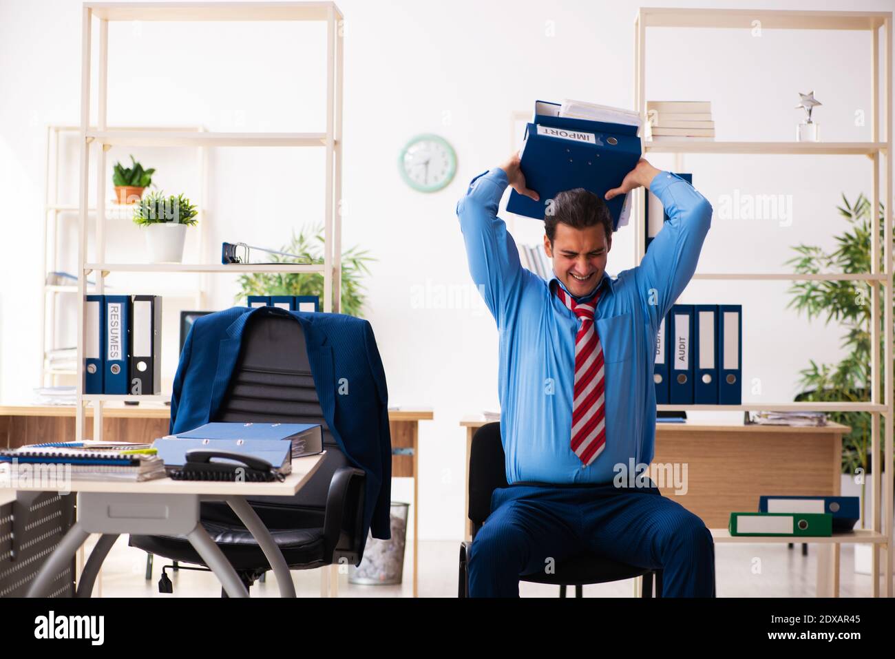 Young businessman doing sport exercises at workplace Stock Photo - Alamy