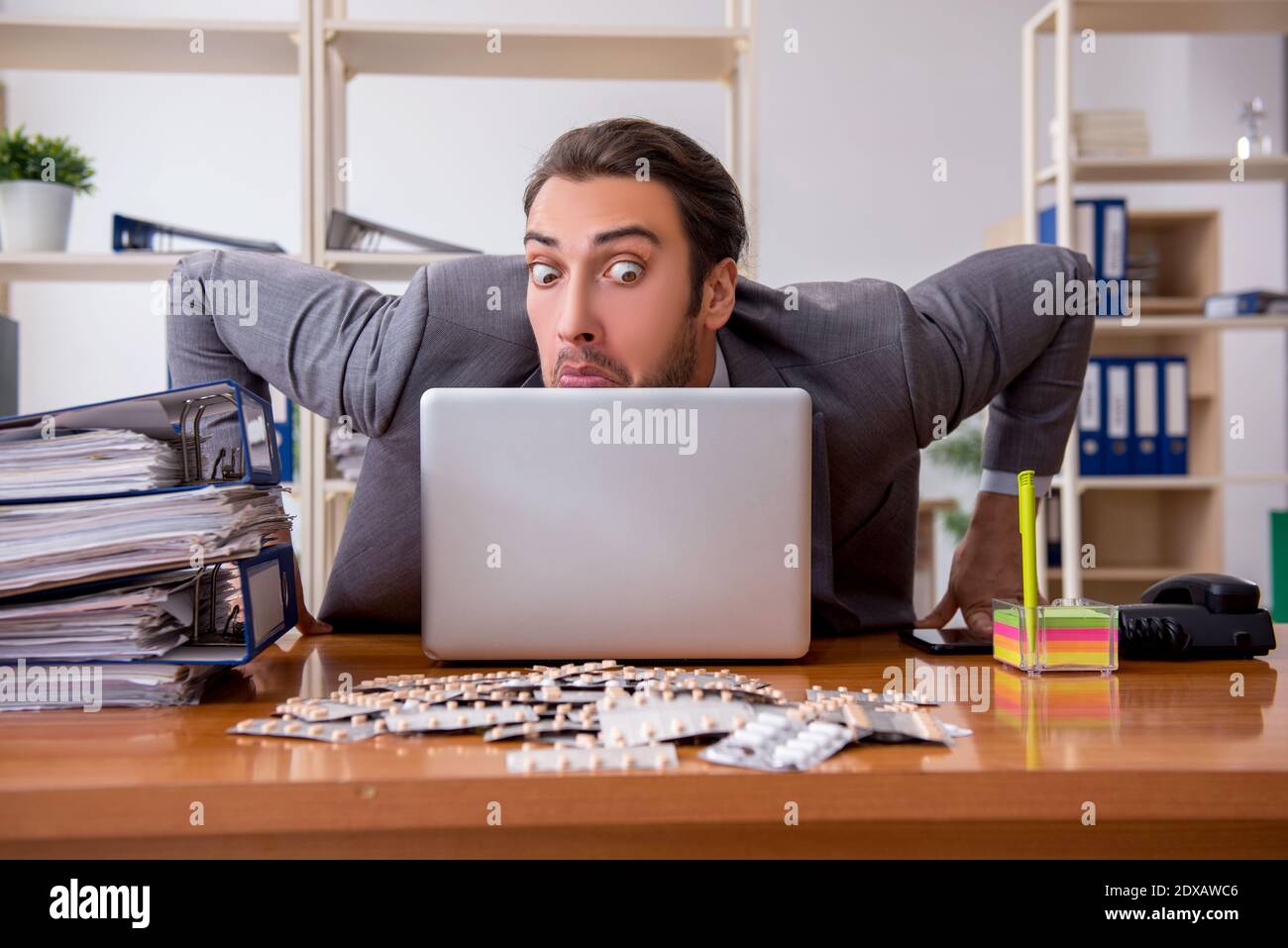 Male sick employee suffering at workplace Stock Photo - Alamy