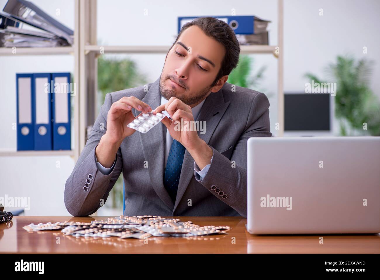 Male sick employee suffering at workplace Stock Photo - Alamy