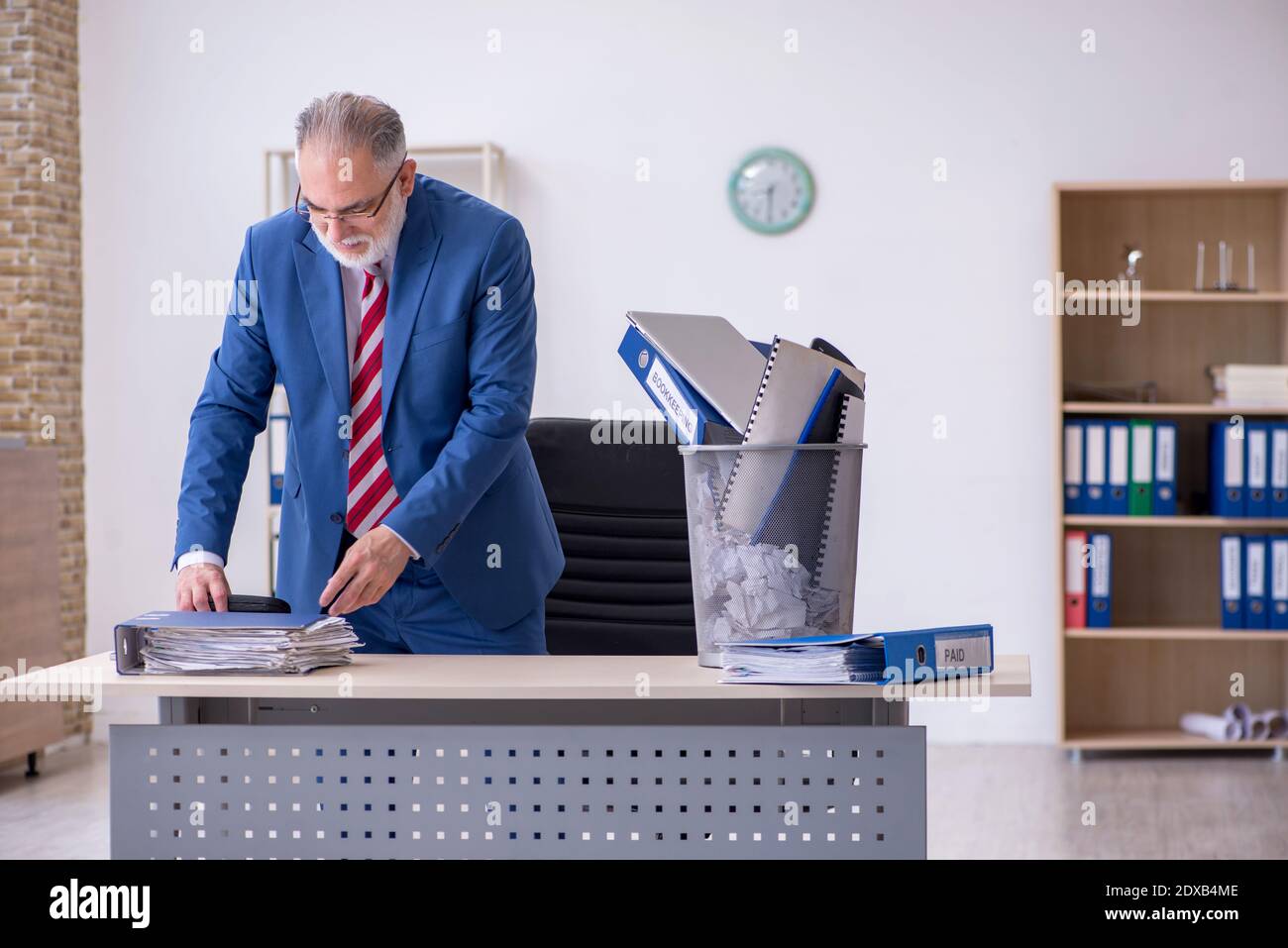 Senior businessman employee rejecting new ideas with lots of papers in ...