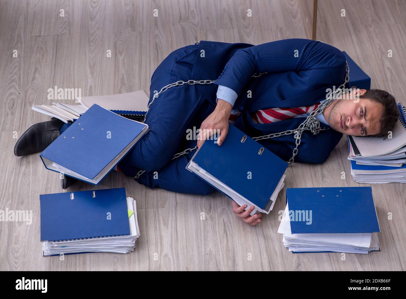 Chained employee unhappy with excessive work in the office Stock Photo ...