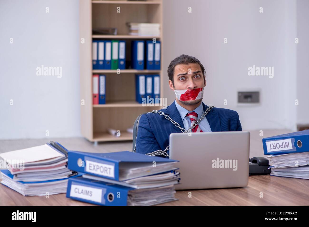 Chained employee unhappy with excessive work in the office Stock Photo ...