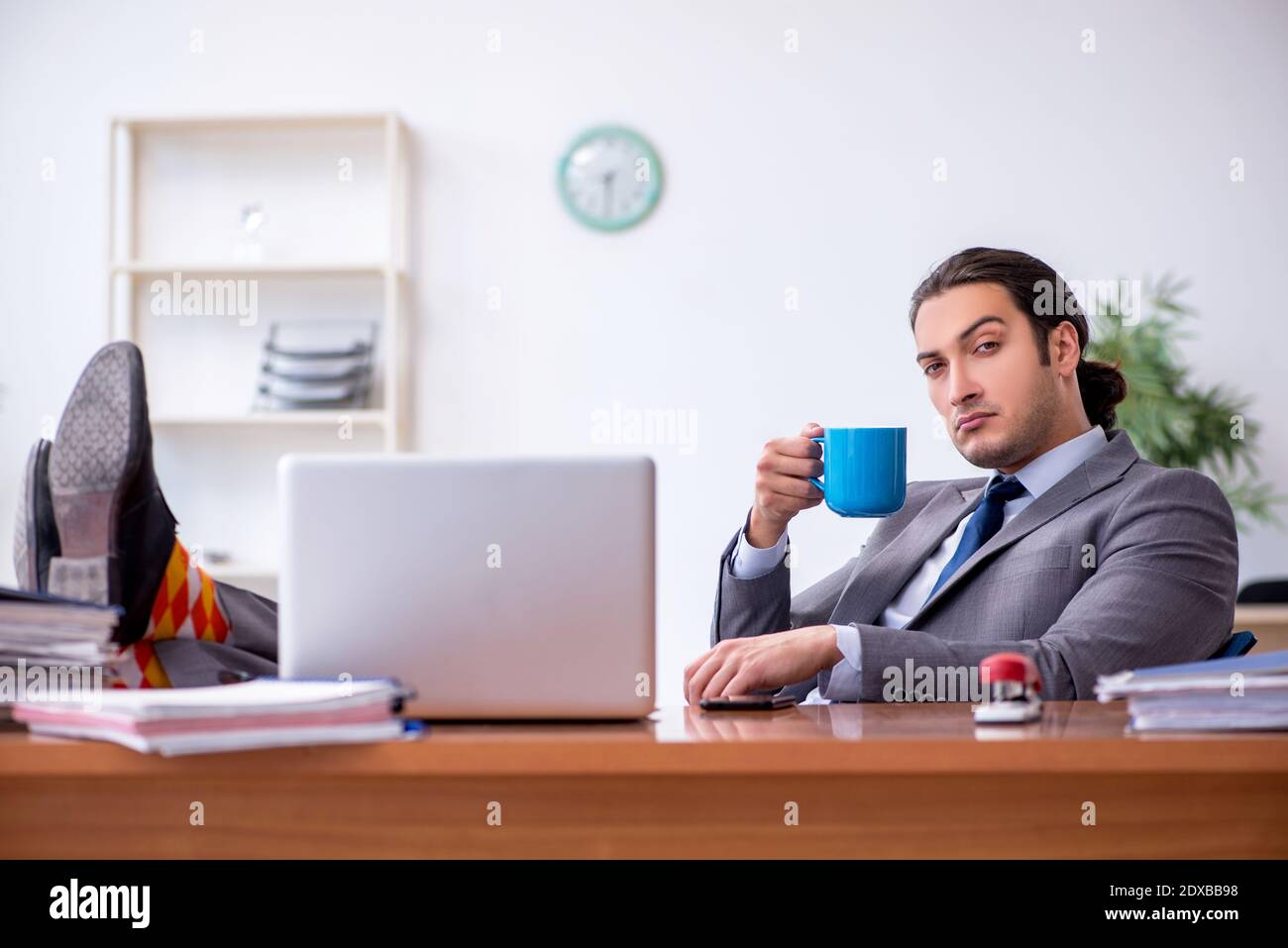 Male employee drinking coffee in the office Stock Photo - Alamy