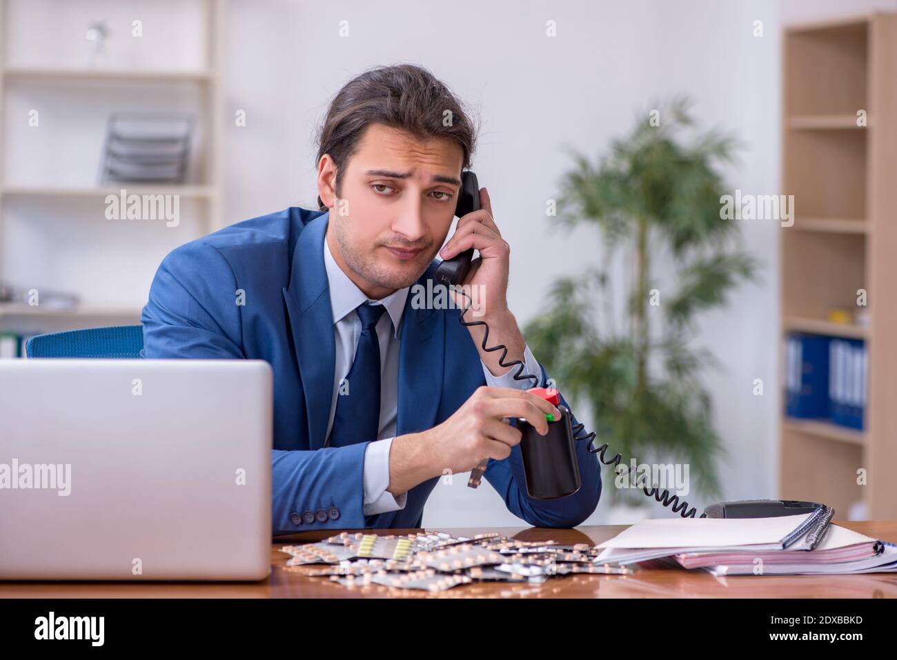 Sick male employee suffering at workplace Stock Photo - Alamy