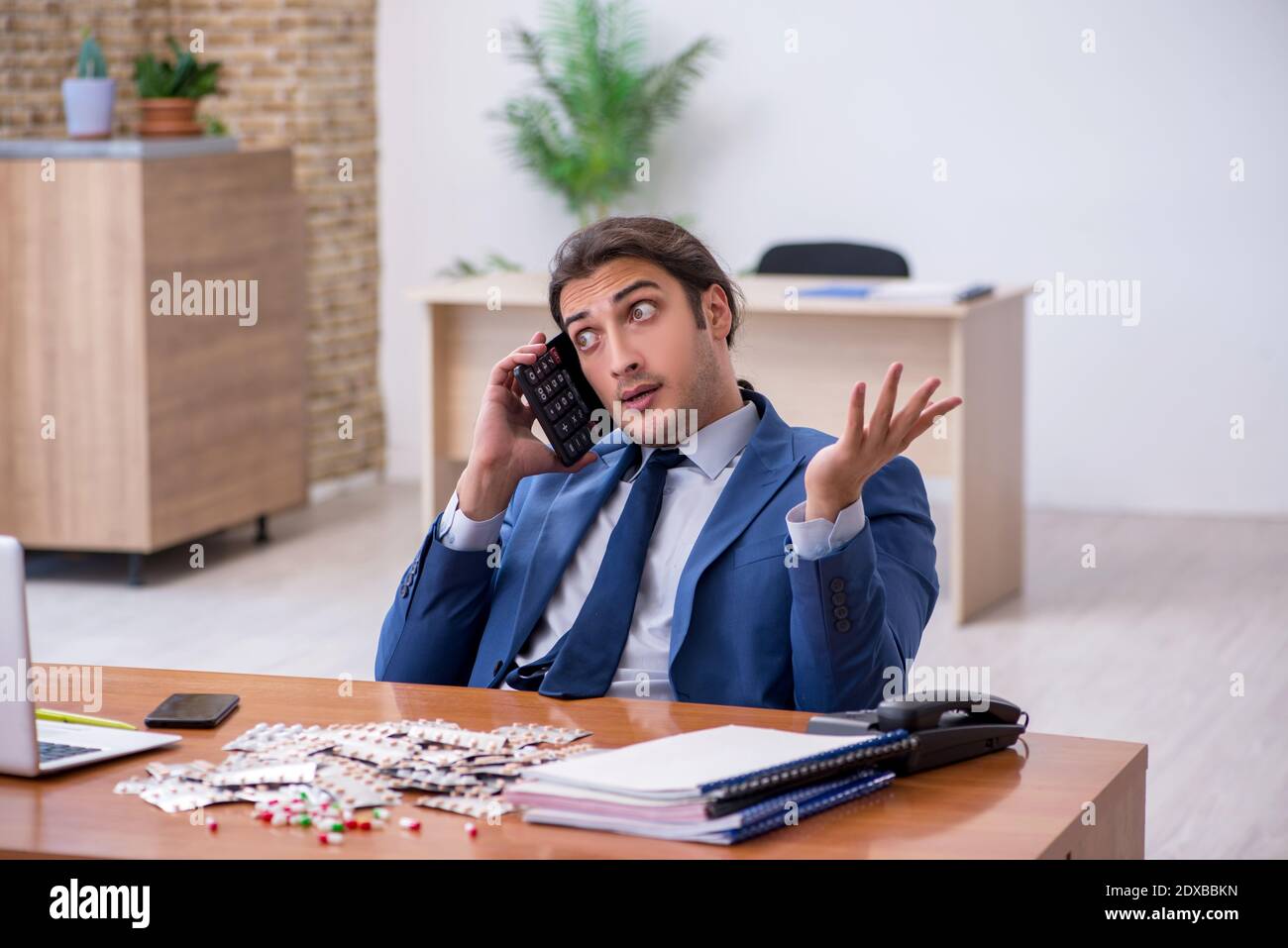 Sick male employee suffering at workplace Stock Photo - Alamy