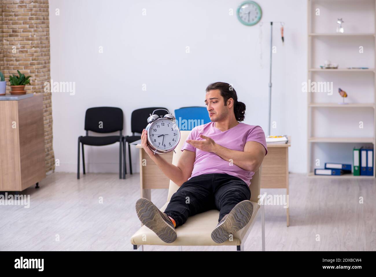 Male patient waiting for doctor in time management concept Stock Photo ...