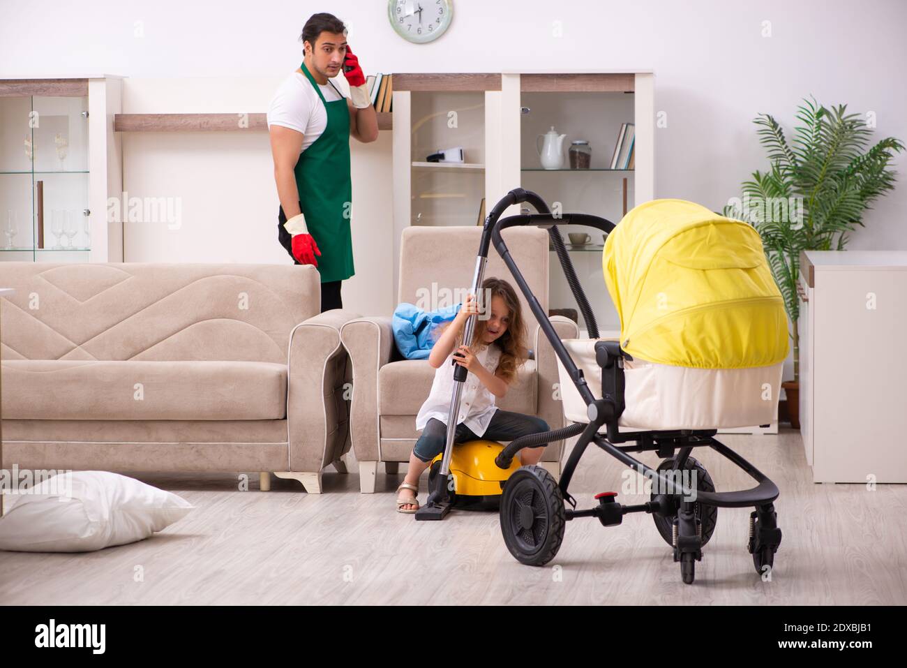 Young contractor cleaning the house with his small daughter Stock Photo ...
