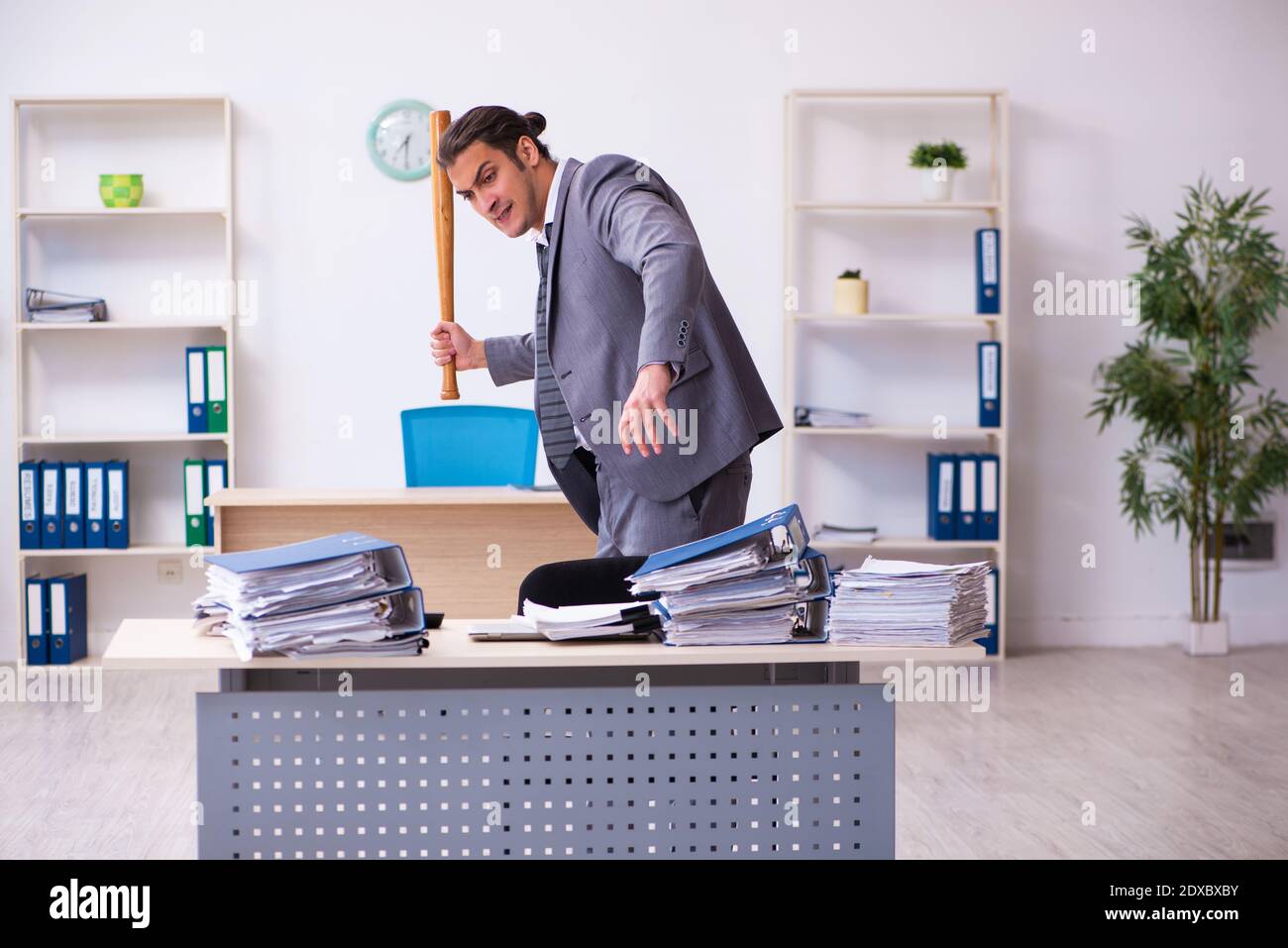 Male employee angry with excessive work holding baseball bat Stock ...