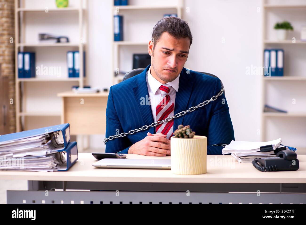 Chained employee working in the office Stock Photo - Alamy