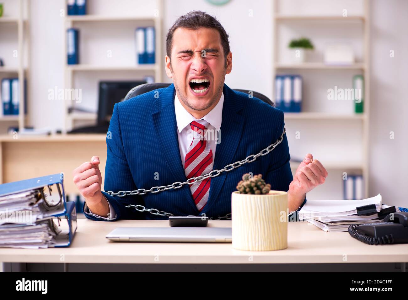 Chained employee working in the office Stock Photo - Alamy