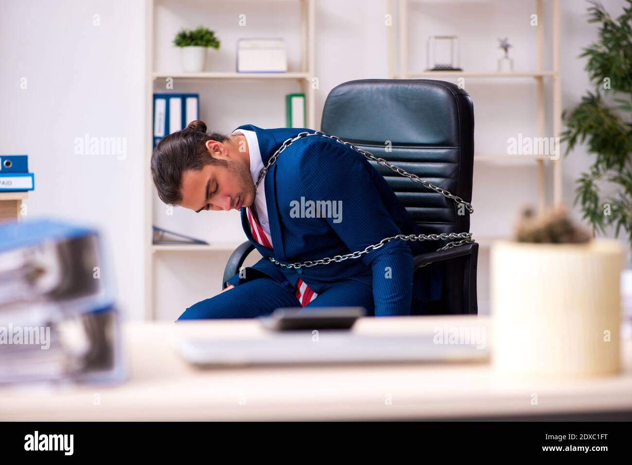 Chained employee working in the office Stock Photo - Alamy