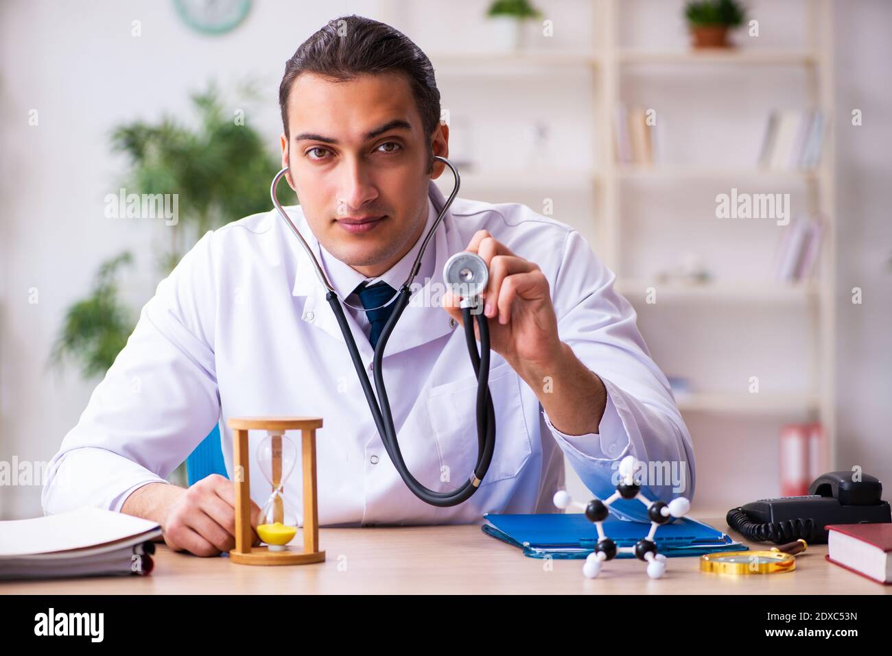 Young doctor in time management concept Stock Photo - Alamy