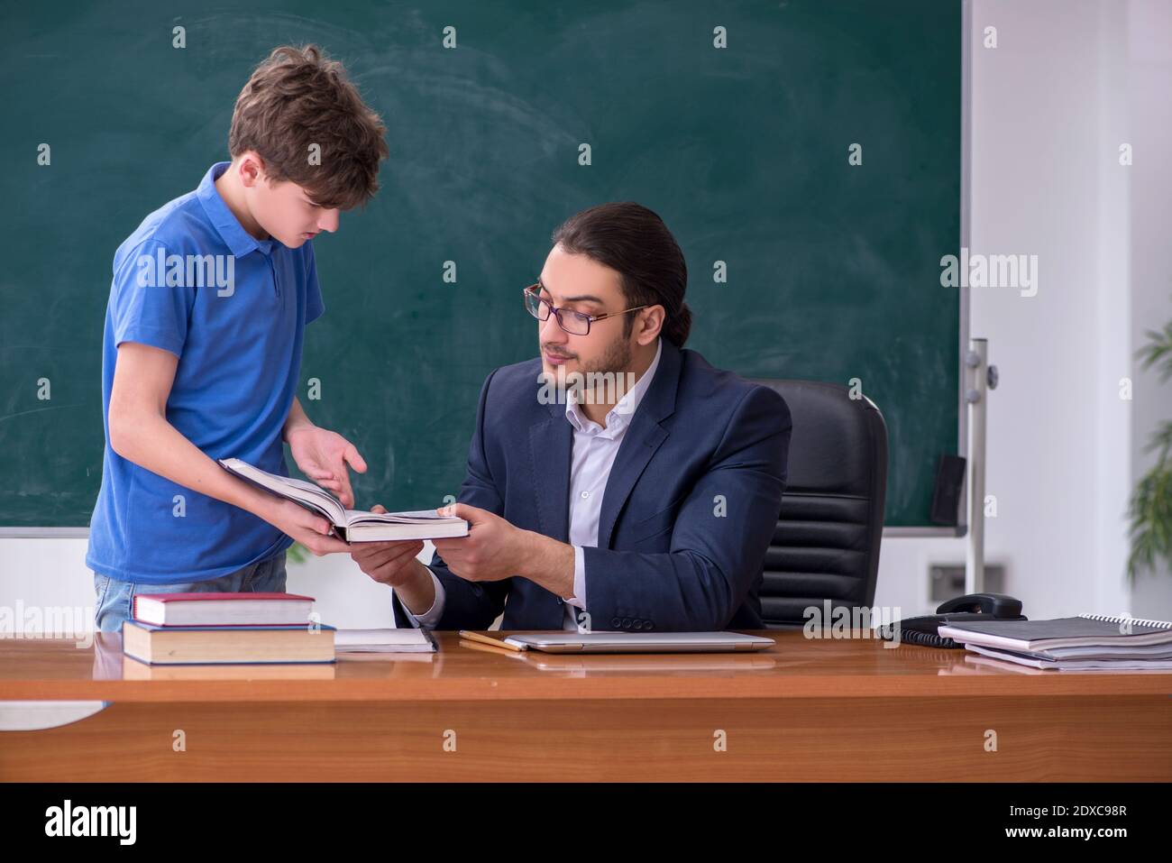 Male teacher and schoolboy in the classroom Stock Photo - Alamy