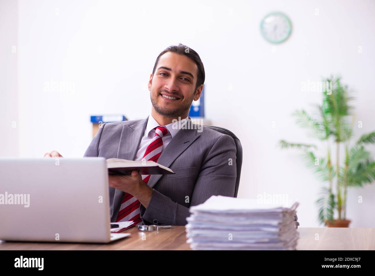 Male employee reading book in the office Stock Photo - Alamy