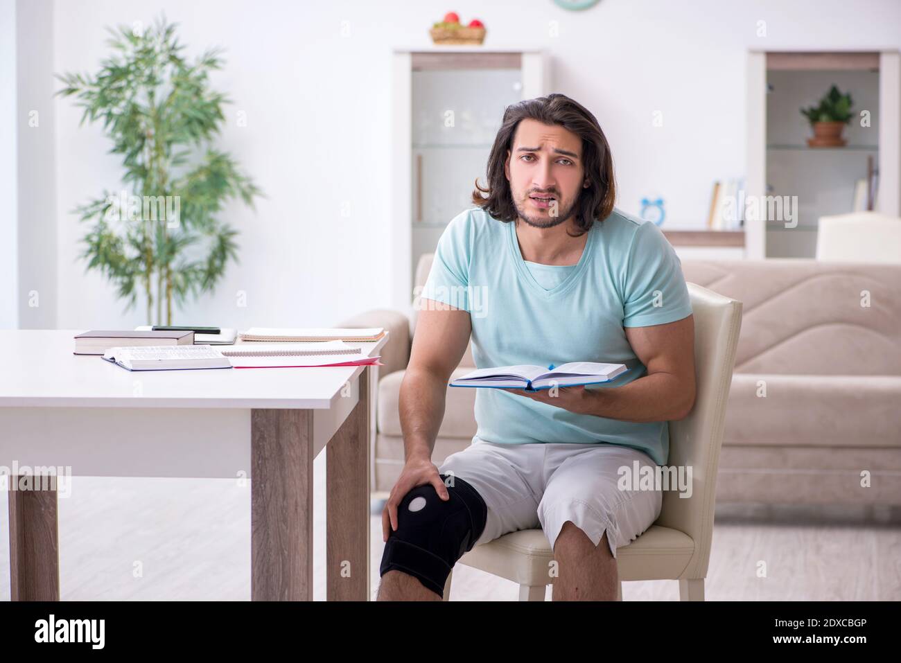 Young leg injured student studying at the home Stock Photo - Alamy