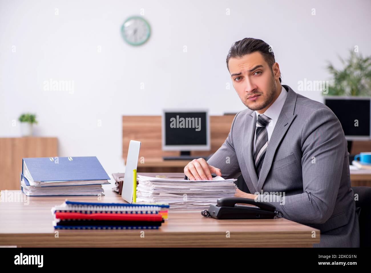 Young male employee working in the office environment Stock Photo - Alamy
