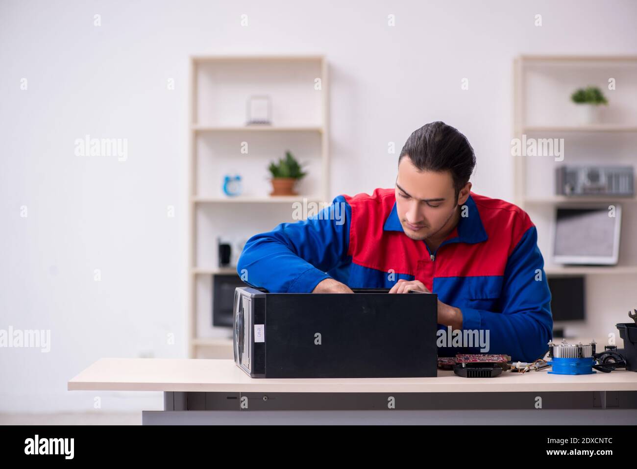 Young male repairman repairing computer PC Stock Photo - Alamy