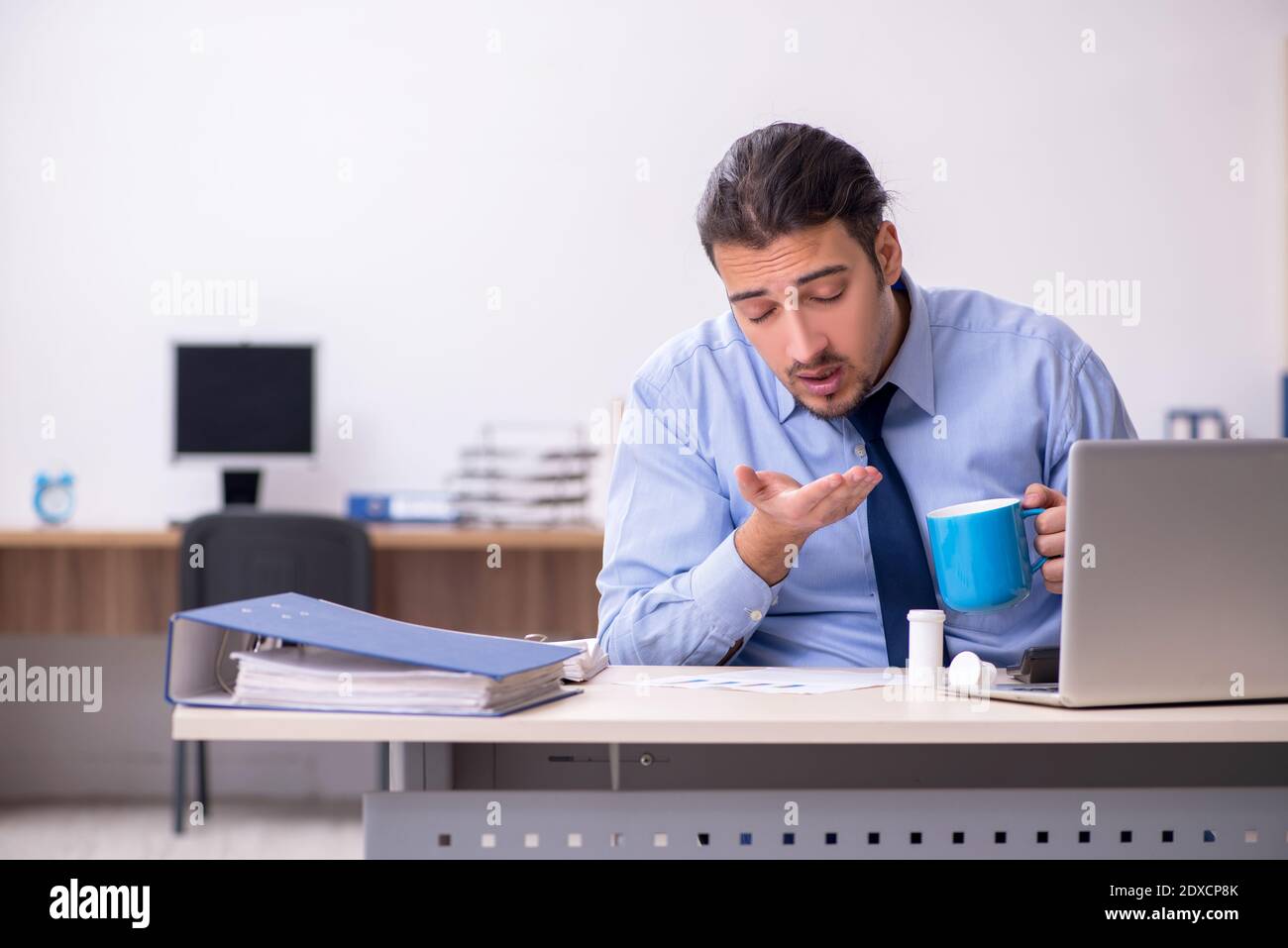 Sick male employee suffering at the workplace Stock Photo - Alamy