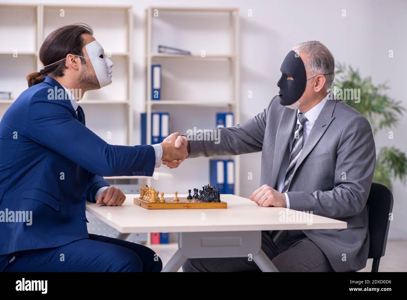 The two businessmen playing chess wearing masks Stock Photo - Alamy
