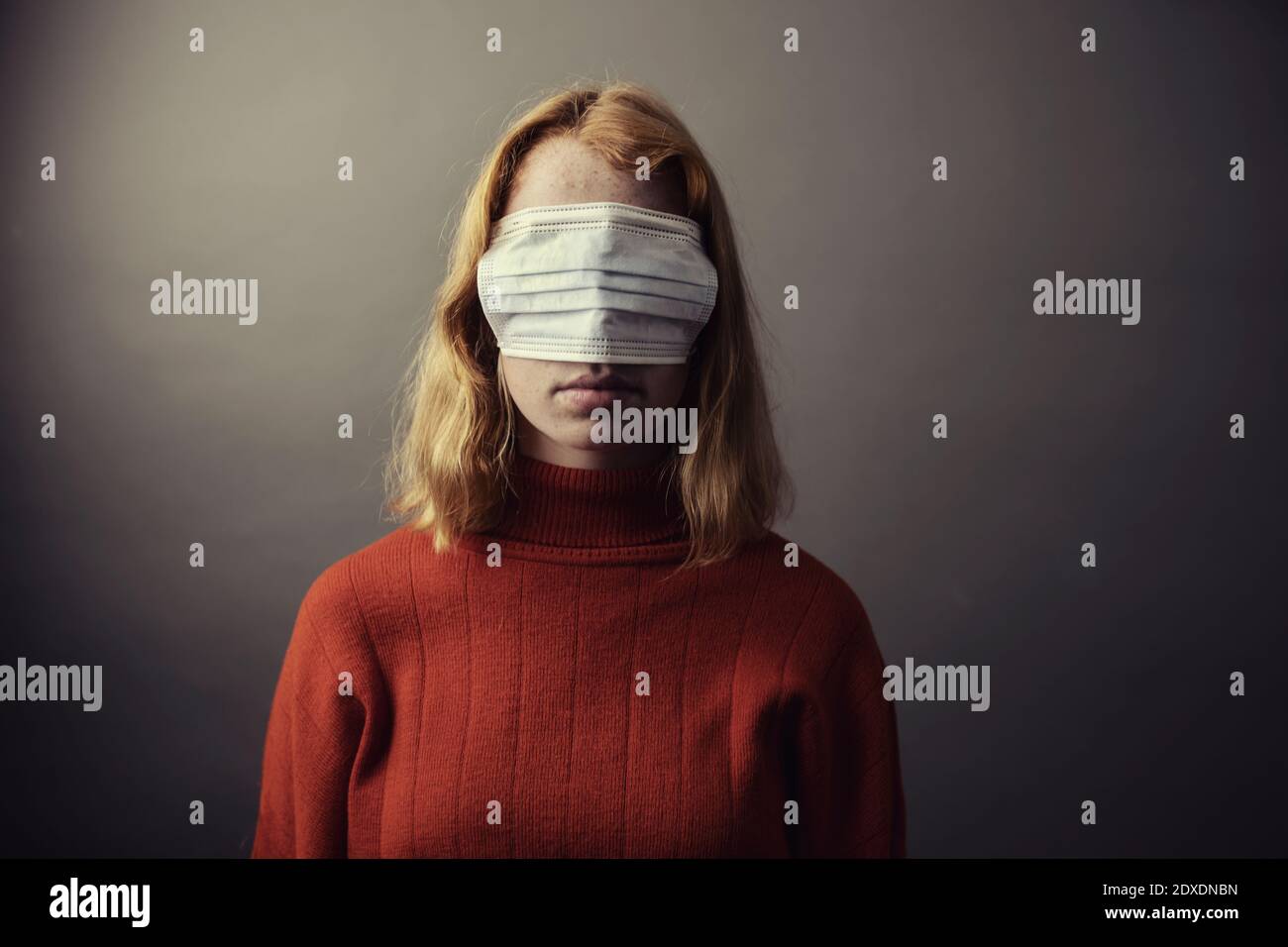 Teenage girl wearing protective face mask on eyes while standing ...