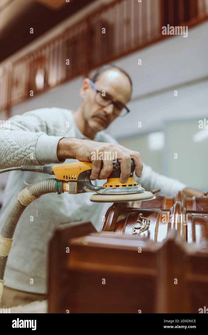 Craftsman using sander for polishing while working at workshop Stock ...