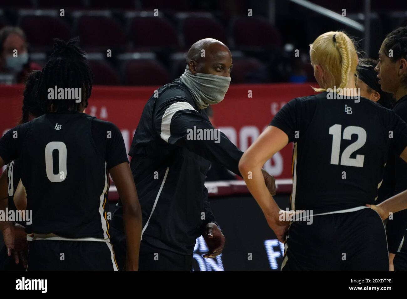 Long Beach State head coach Jeff Cammon wears a face mask in timeout as ...
