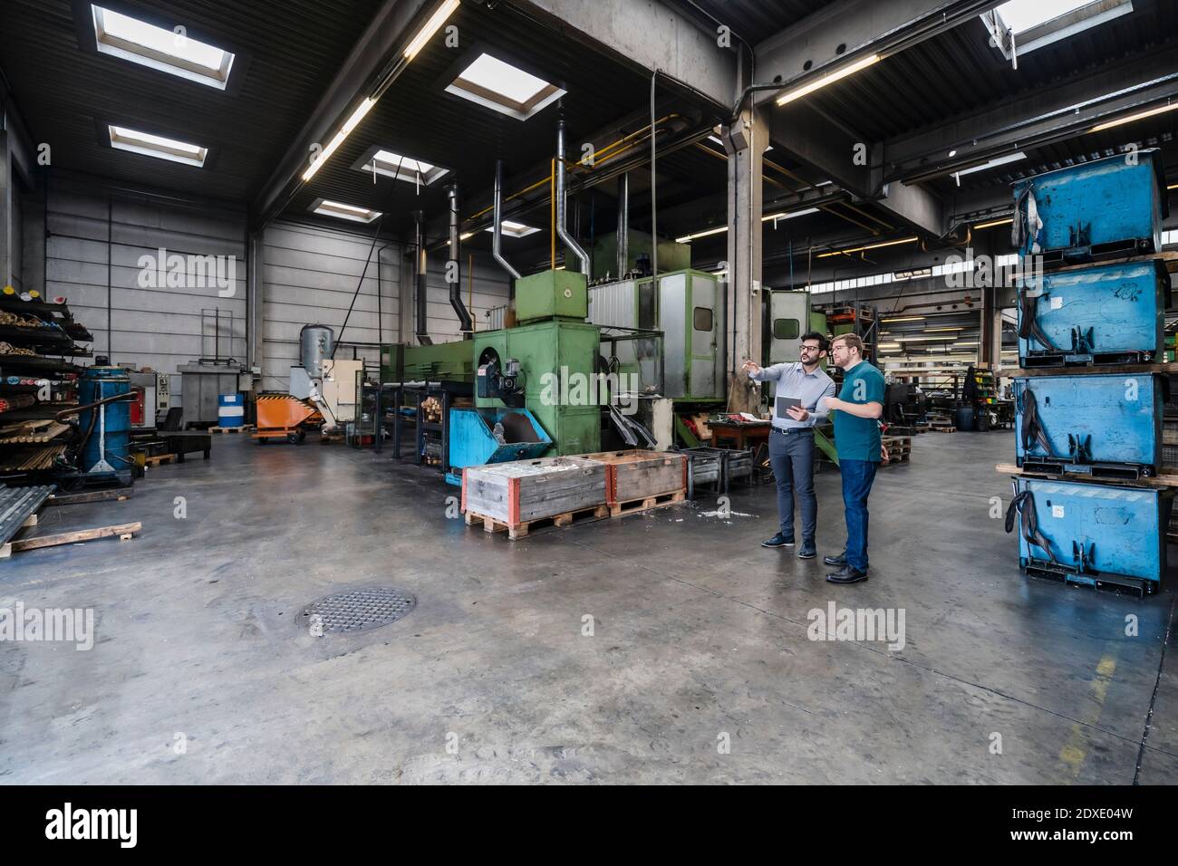 Male colleagues standing in manufacturing factory Stock Photo - Alamy