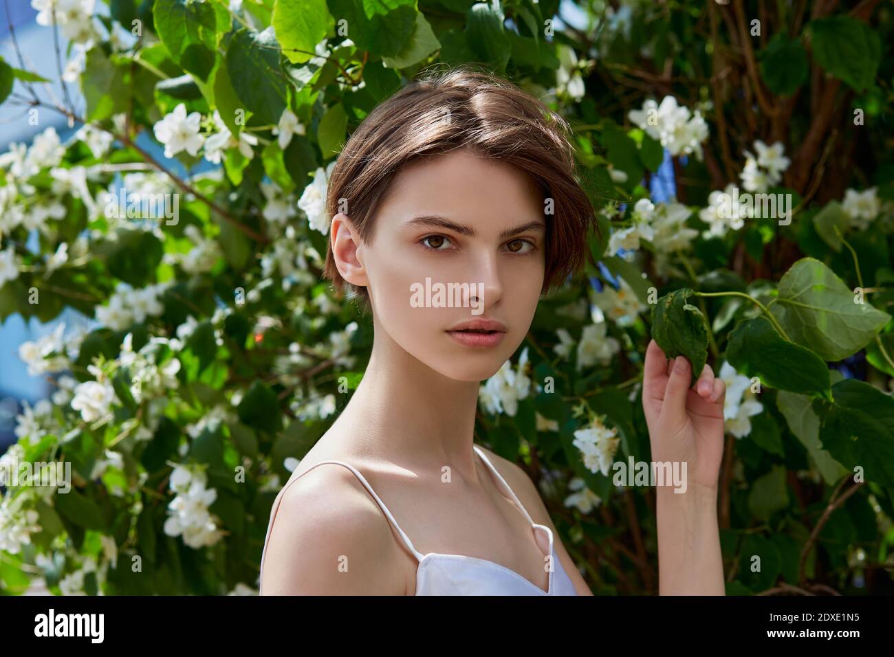 Attractive modest young woman natural makeup in a white dress outdoors ...