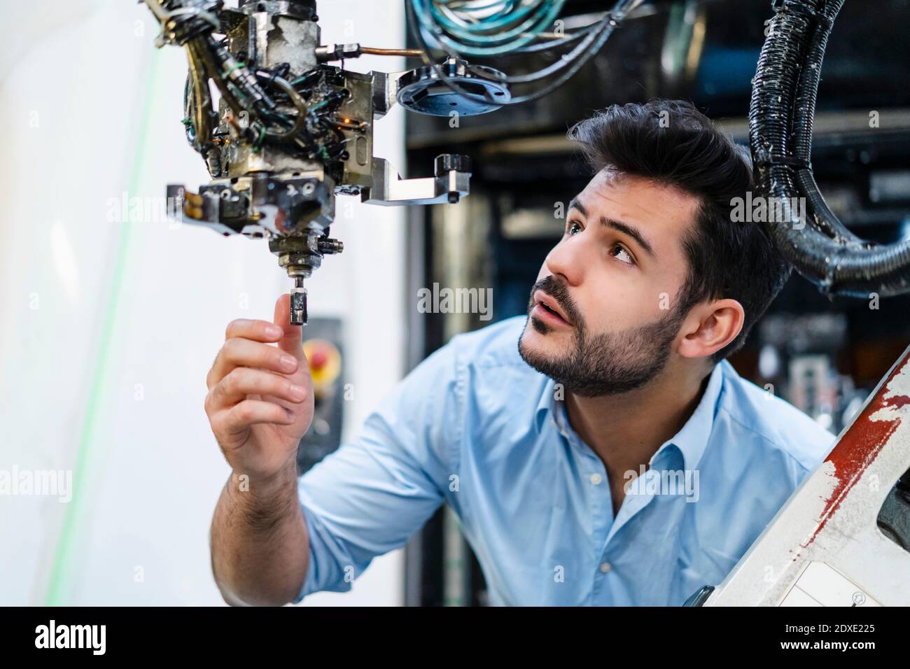 Male entrepreneur concentrating while analyzing robotic arm in ...