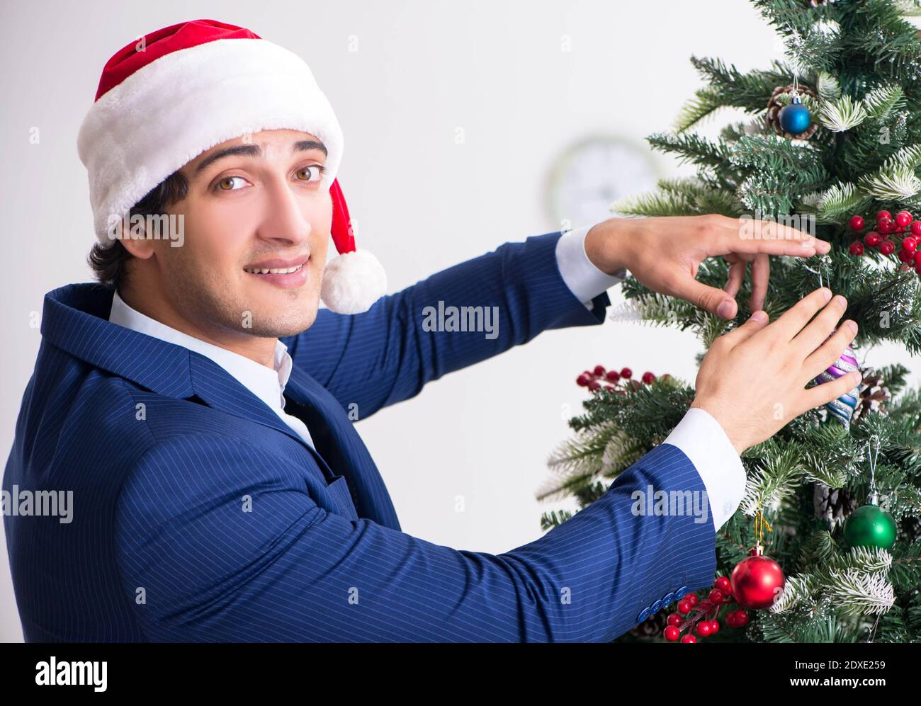 The young employee celebrating christmas at workplace Stock Photo - Alamy