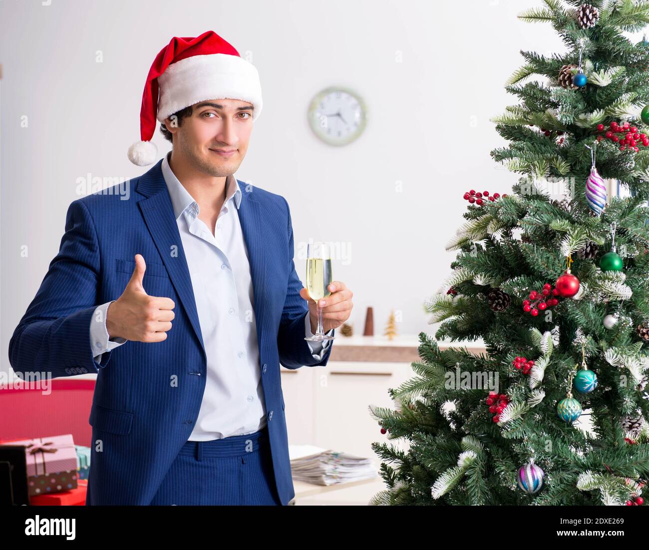 The young employee celebrating christmas at workplace Stock Photo - Alamy