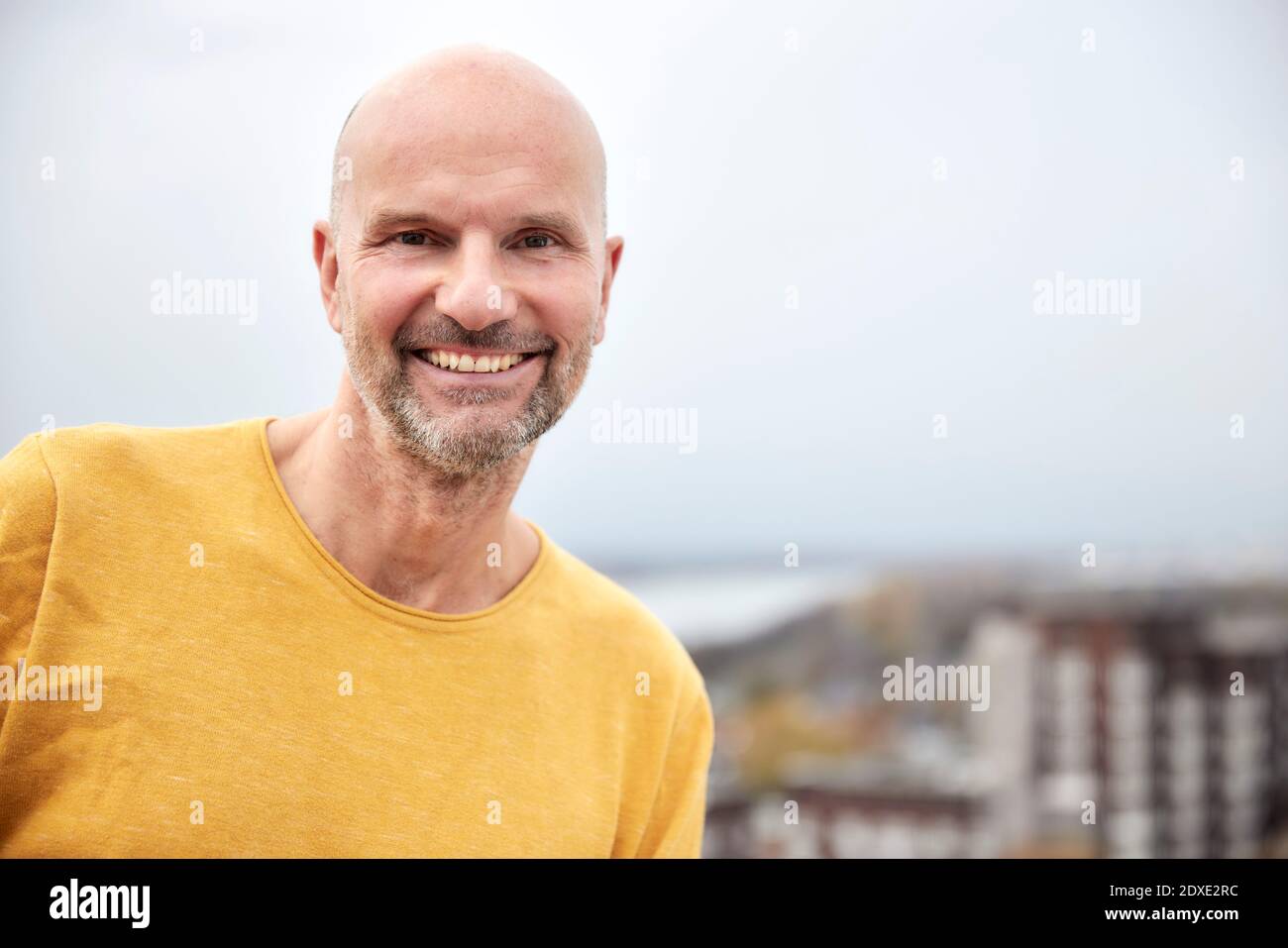 Smiling man standing on rooftop Stock Photo - Alamy