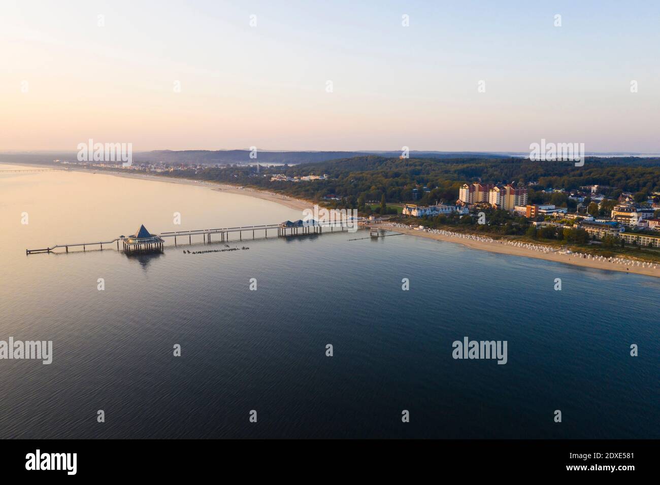 Germany, Usedom. Pier in sea and holiday resort at sunset, aerial view ...