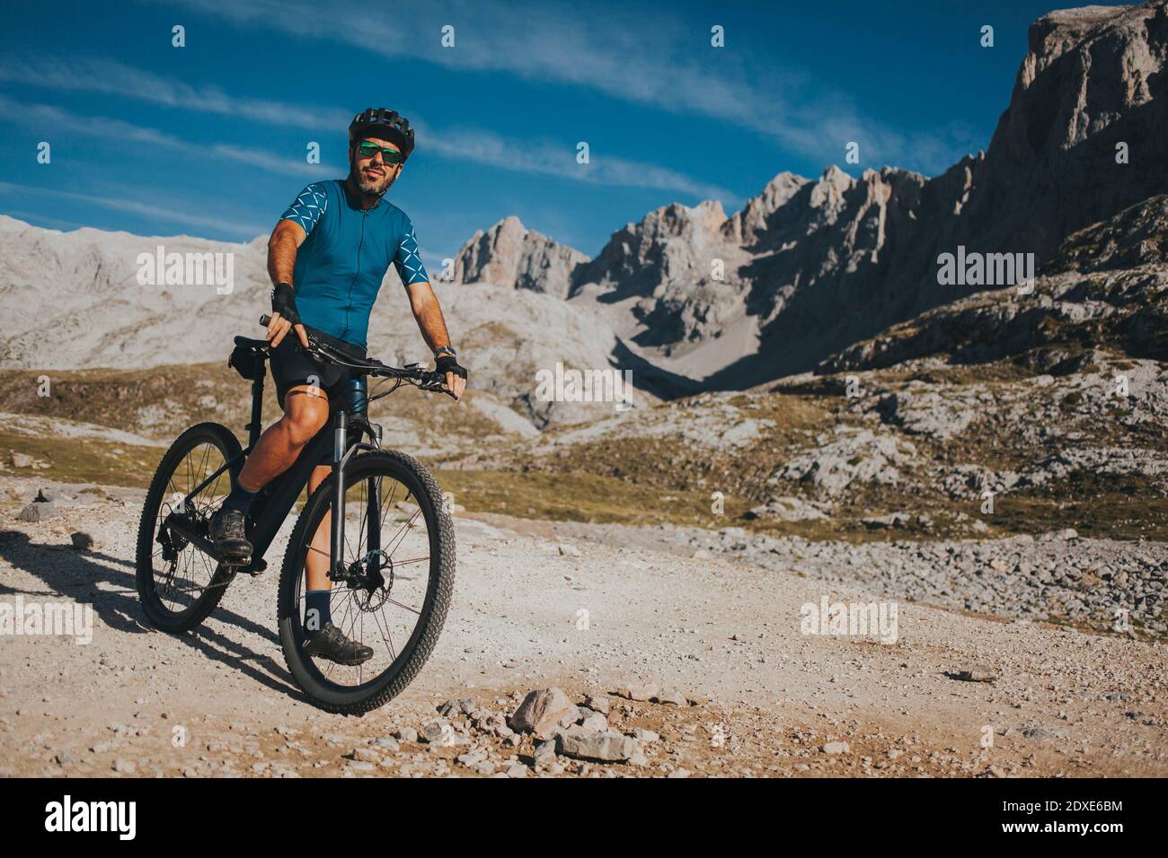 Mountain cyclist with bicycle exploring Picos de Europa National Park ...