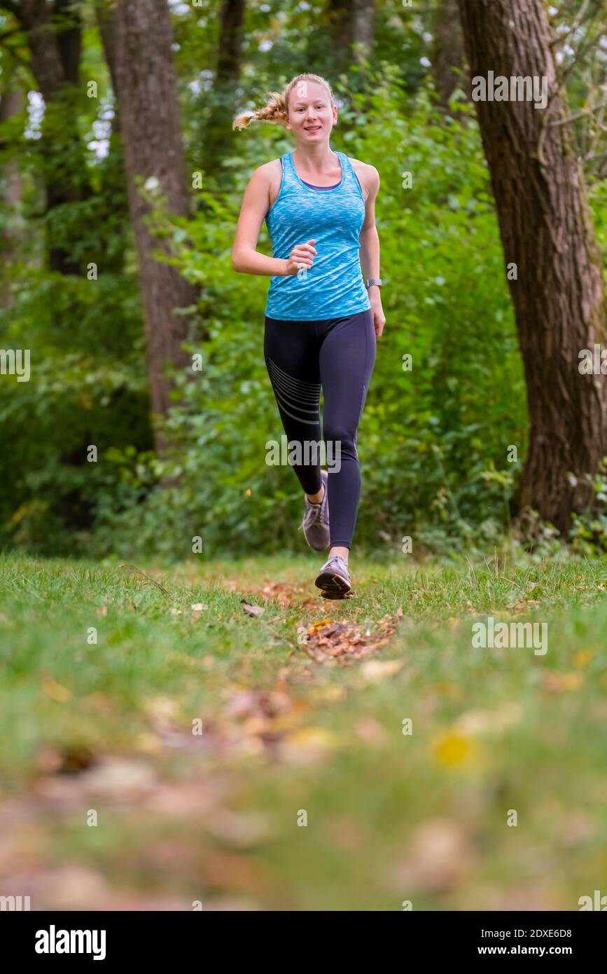 Active female athlete jogging in forest Stock Photo - Alamy
