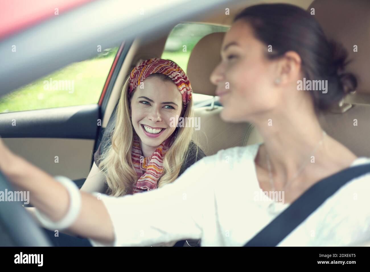 Smiling friends talking while riding in car on road trip Stock Photo ...