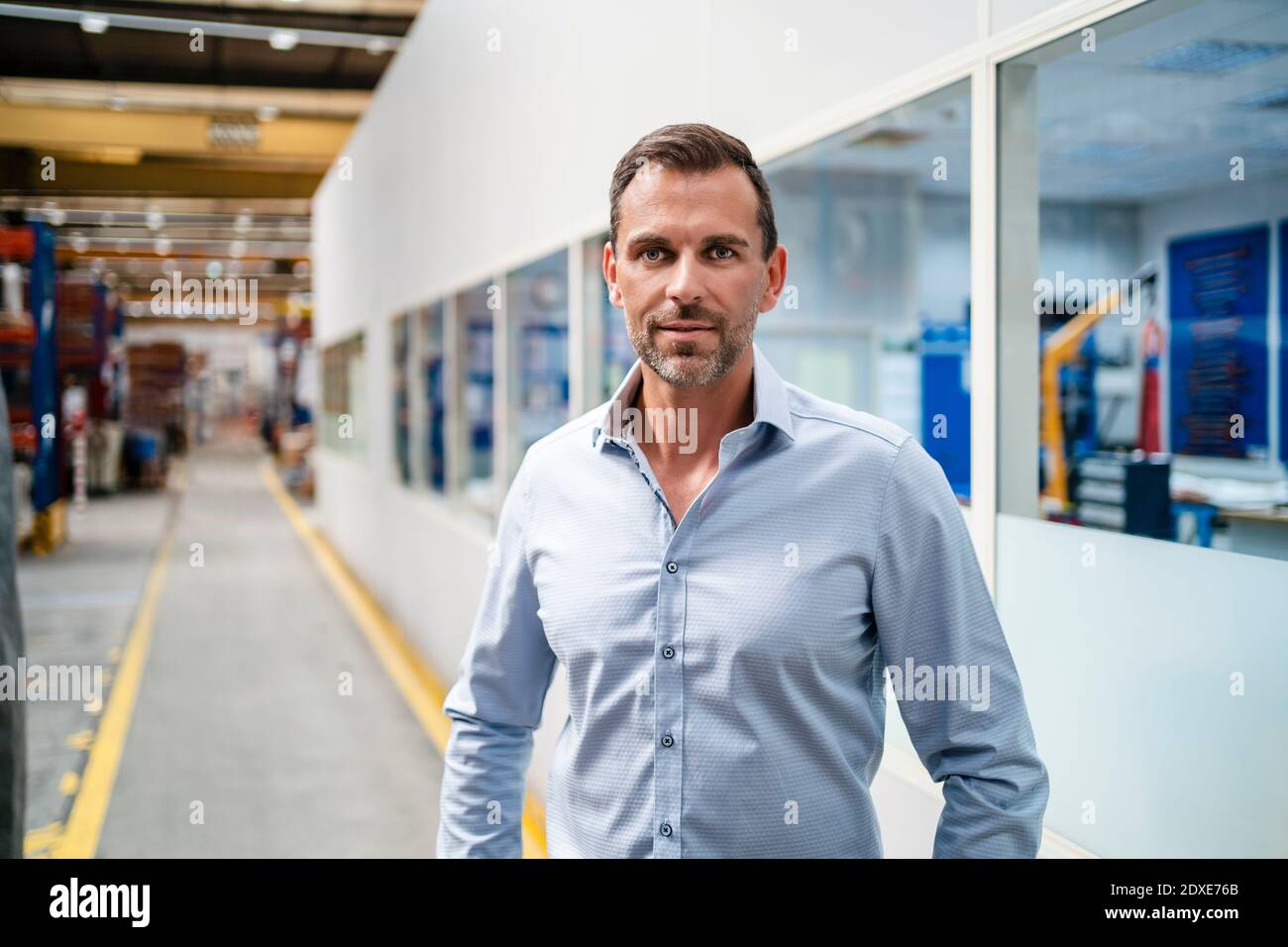 Confident male entrepreneur standing in industry Stock Photo - Alamy