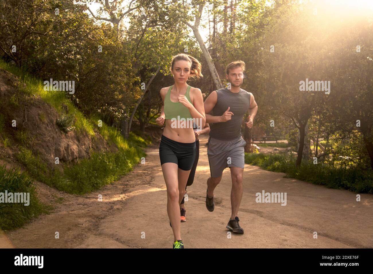 Athletes exercising while running together on footpath Stock Photo - Alamy