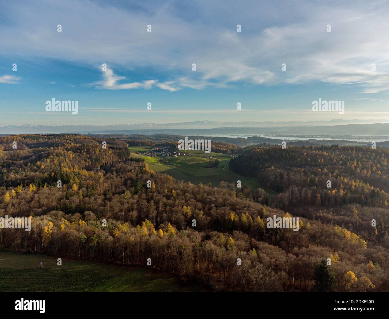 Aerial view of autumn forest with village in background Stock Photo - Alamy