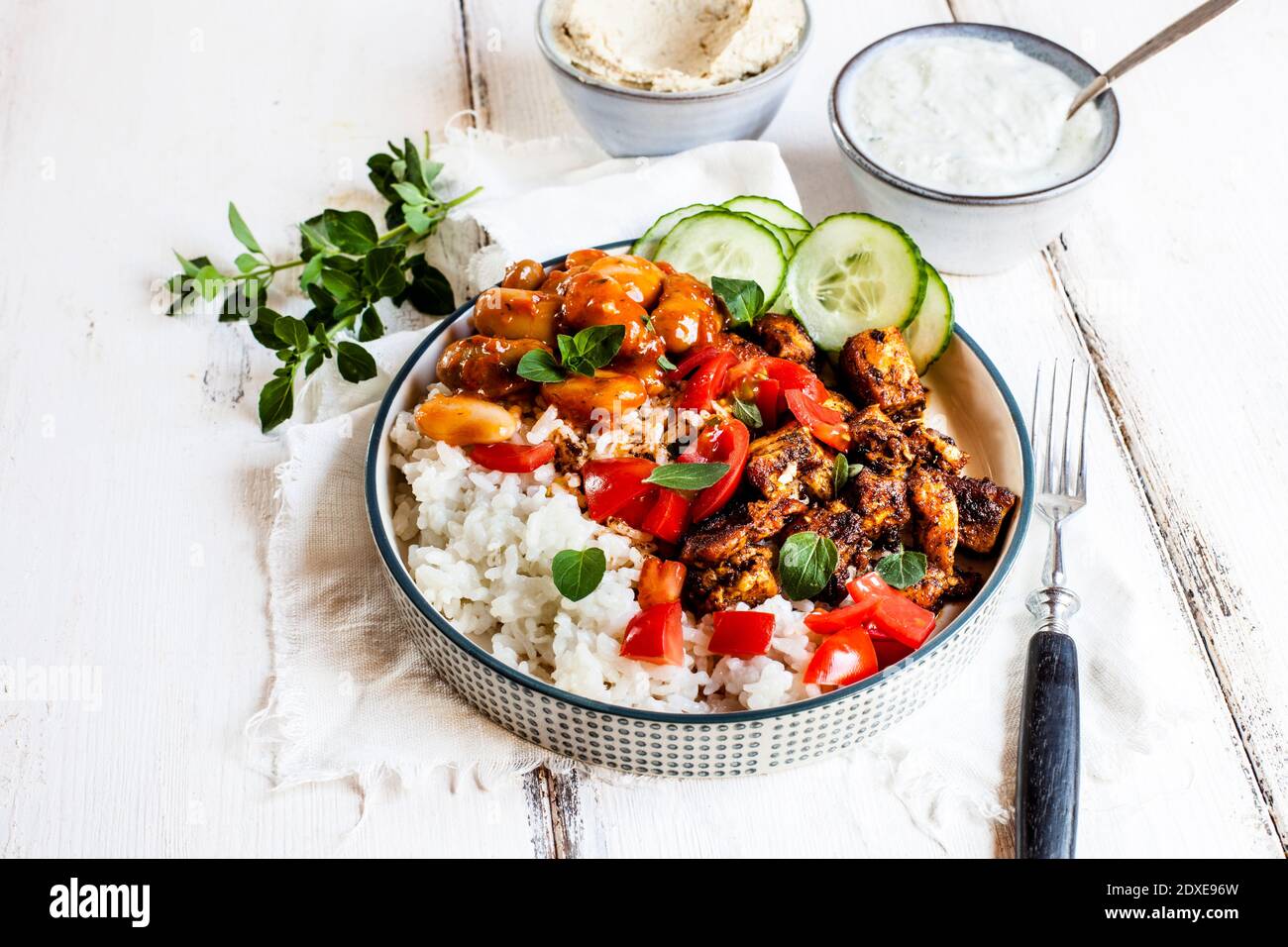 Bowl of Greek gyro with rice, fava beans, halloumi cheese, tomatoes and ...