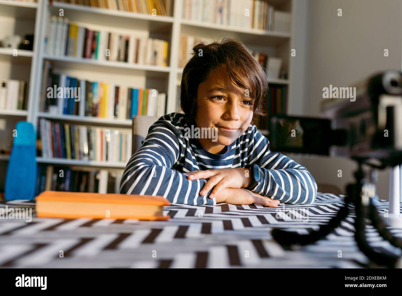 Boy vlogging with video camera at table in living room Stock Photo - Alamy