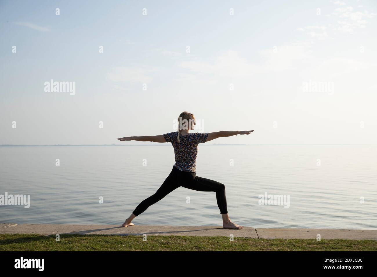 Active woman practicing warrior position at promenade Stock Photo - Alamy